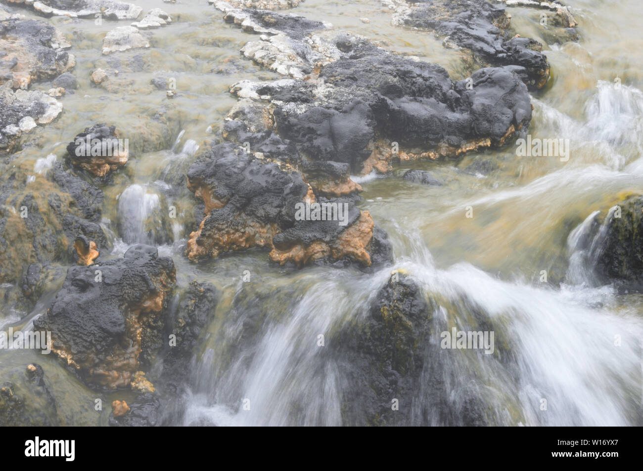Natural hot spring water flow over rocks at Fire Hole Spring Stock ...