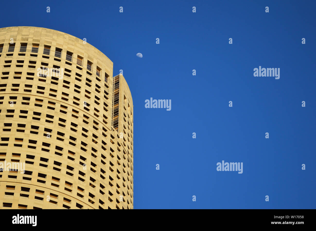 Downtown round building with half moon in blue sky Stock Photo - Alamy