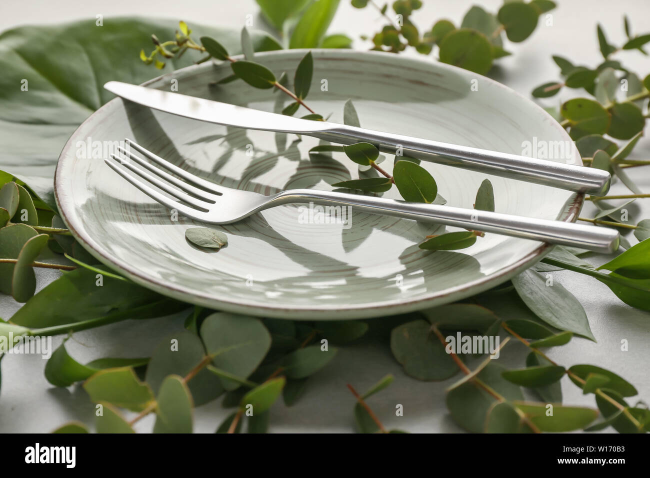 Simple table setting with tropical leaves Stock Photo - Alamy