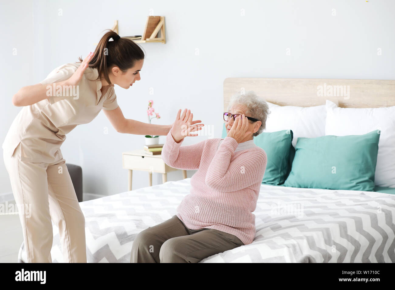 Caregiver mistreating senior woman in nursing home Stock Photo - Alamy