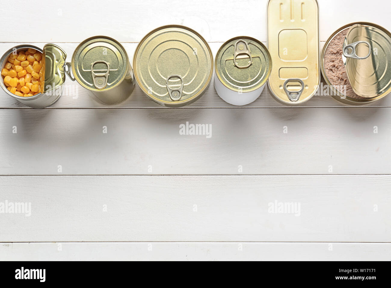 Tin cans with food on white wooden background Stock Photo - Alamy