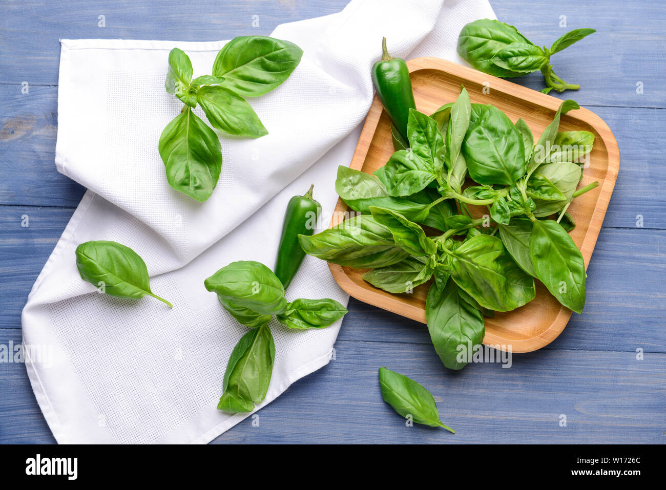Plate with fresh basil and peppers on color wooden background Stock ...