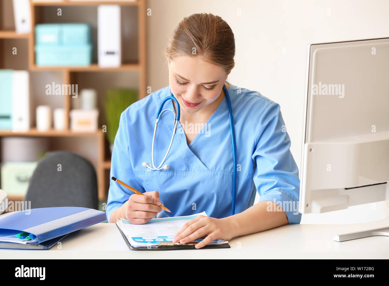 Young medical assistant working in clinic Stock Photo - Alamy