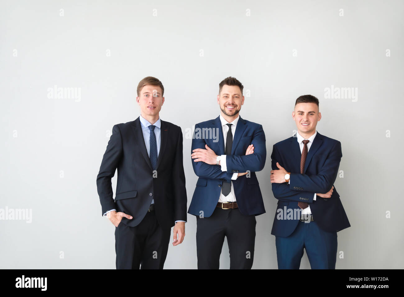 Team of businessmen on light background Stock Photo - Alamy