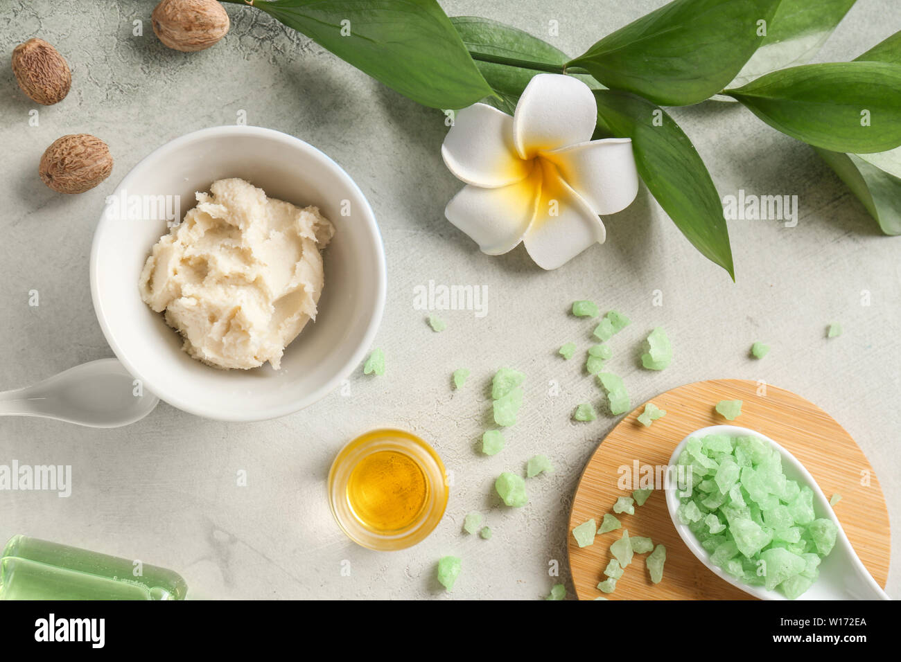 Shea butter with cosmetic products on light background Stock Photo - Alamy