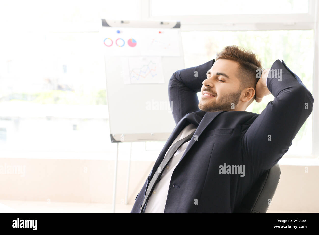 Handsome businessman having break during work in office Stock Photo - Alamy
