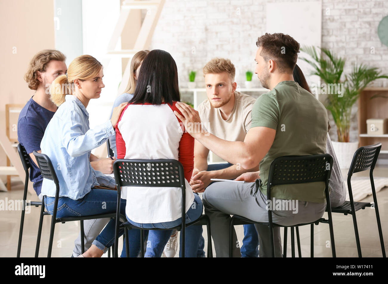People calming woman at group therapy session Stock Photo - Alamy