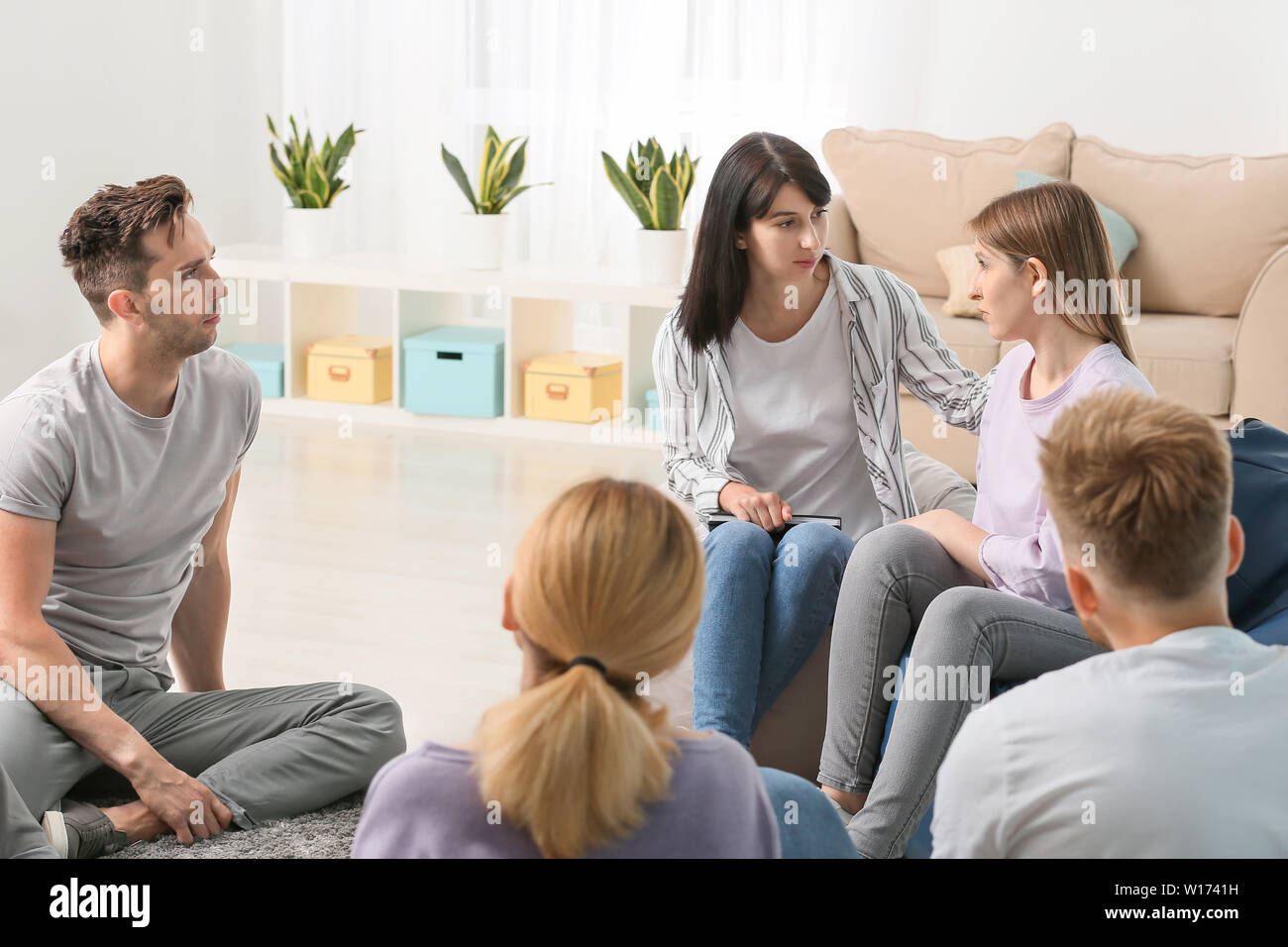 People calming woman at group therapy session Stock Photo - Alamy