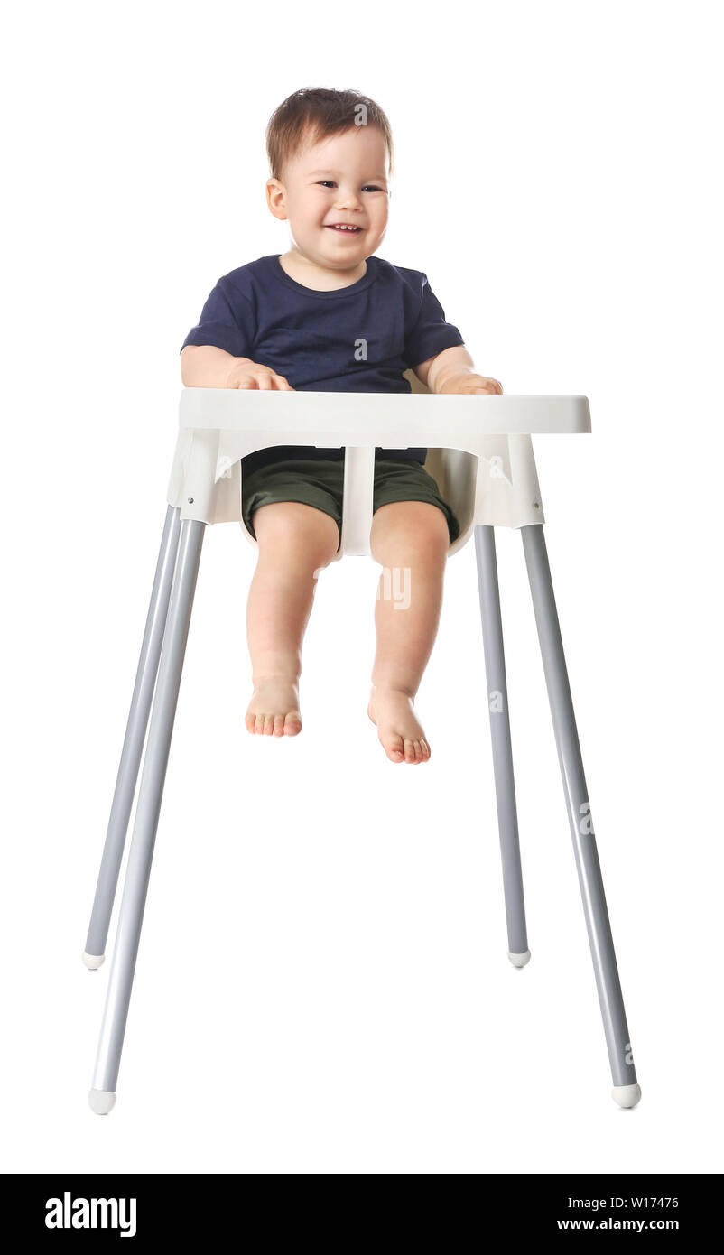 Cute baby boy sitting in high chair against white background Stock ...