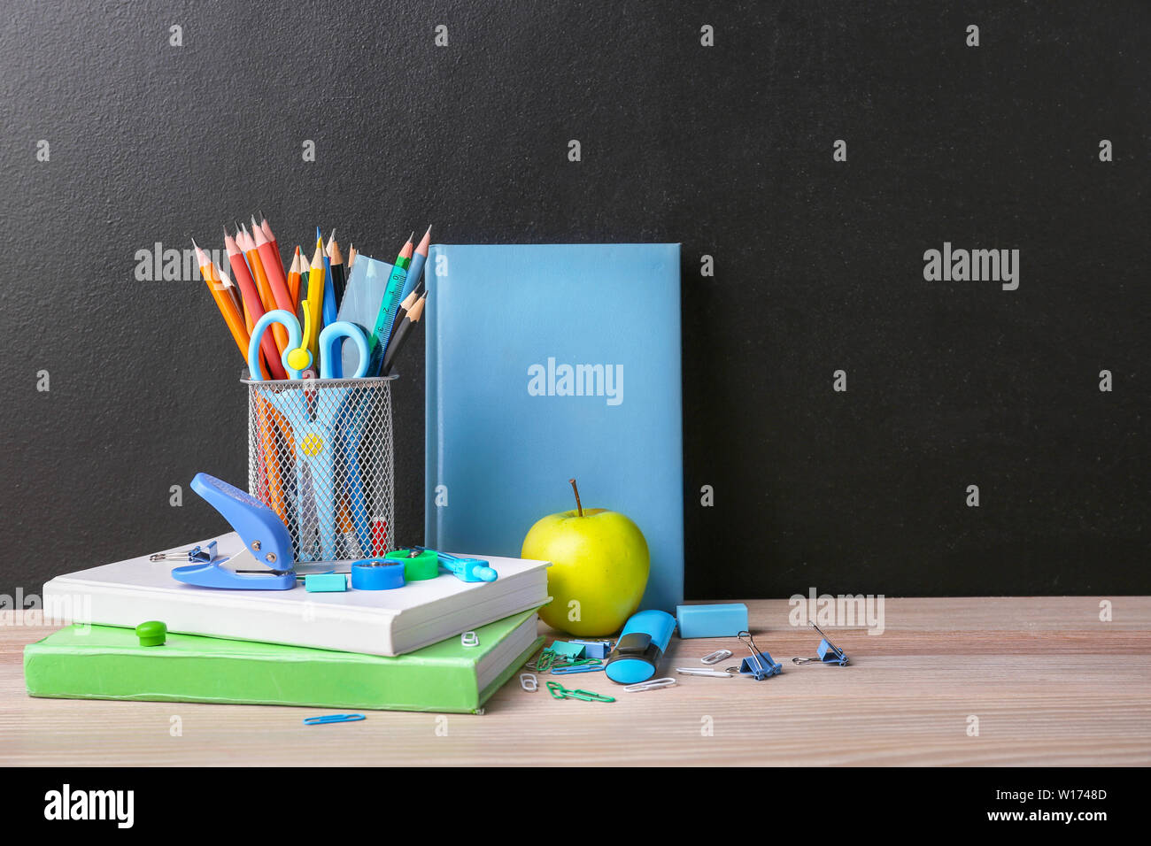 Set of school supplies on table in classroom Stock Photo - Alamy