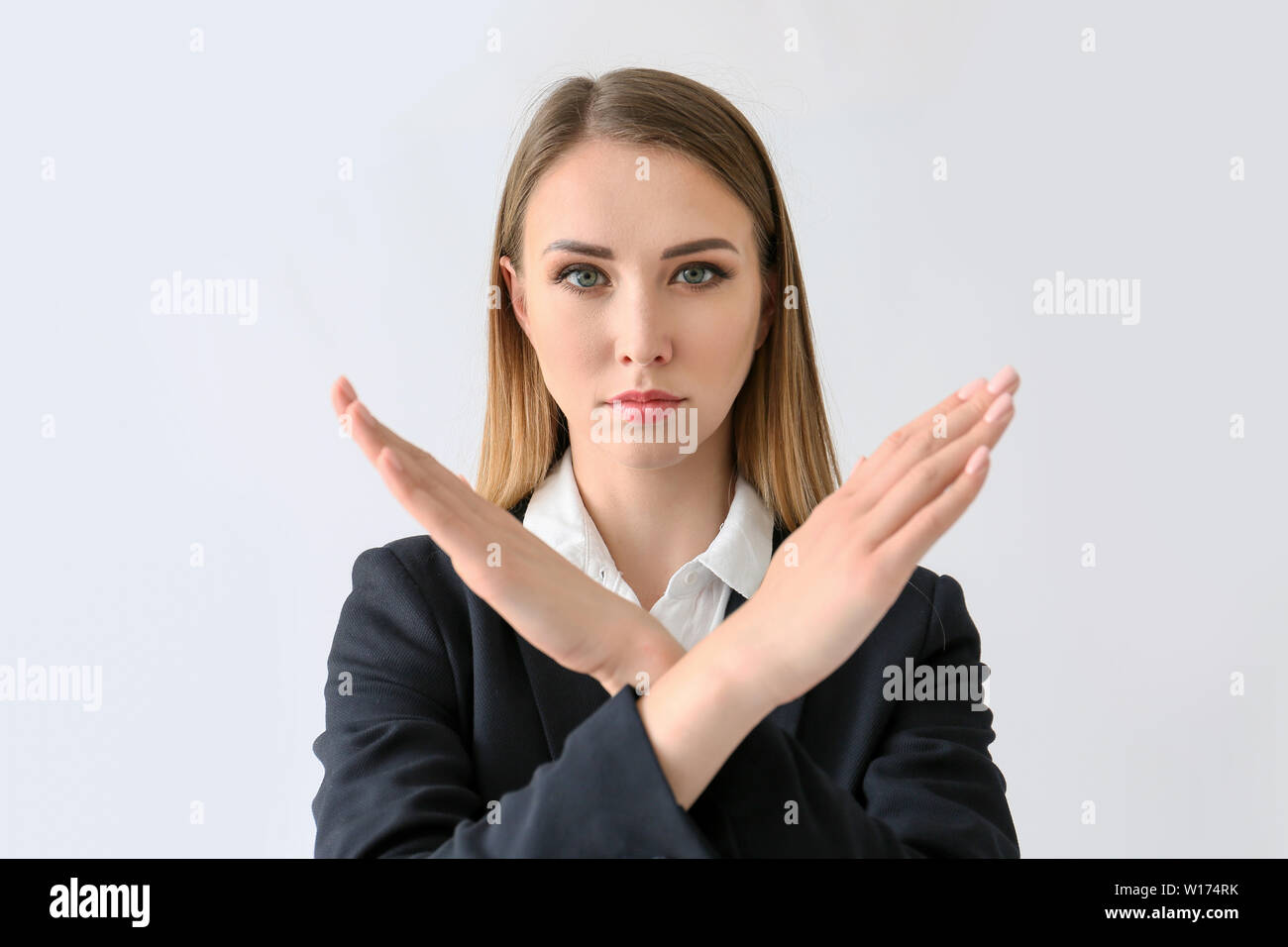 Beautiful young businesswoman rejecting something on white background ...