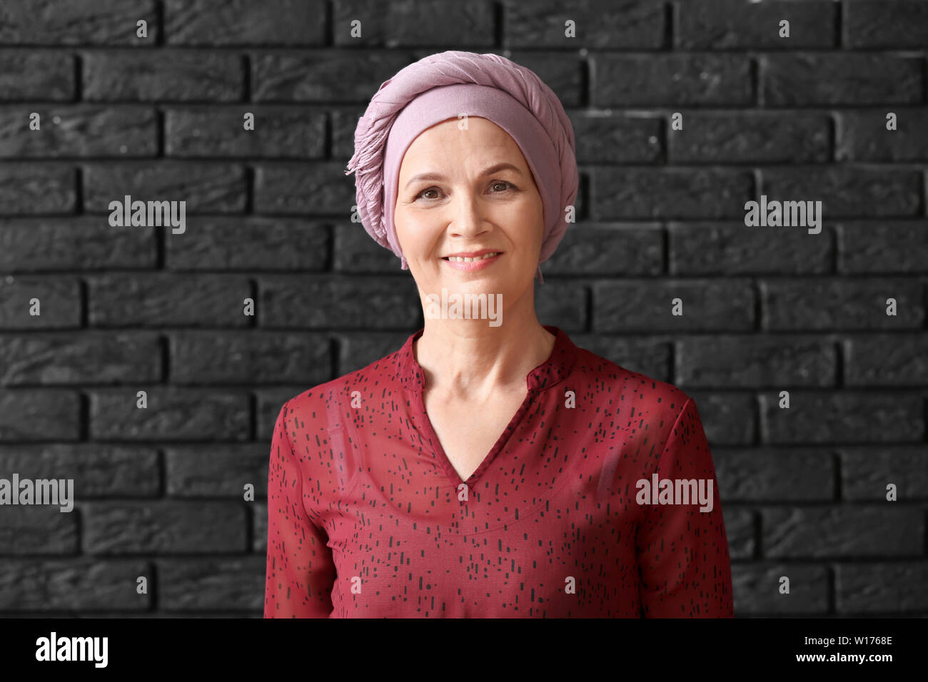 Mature woman after chemotherapy on dark brick background Stock Photo ...