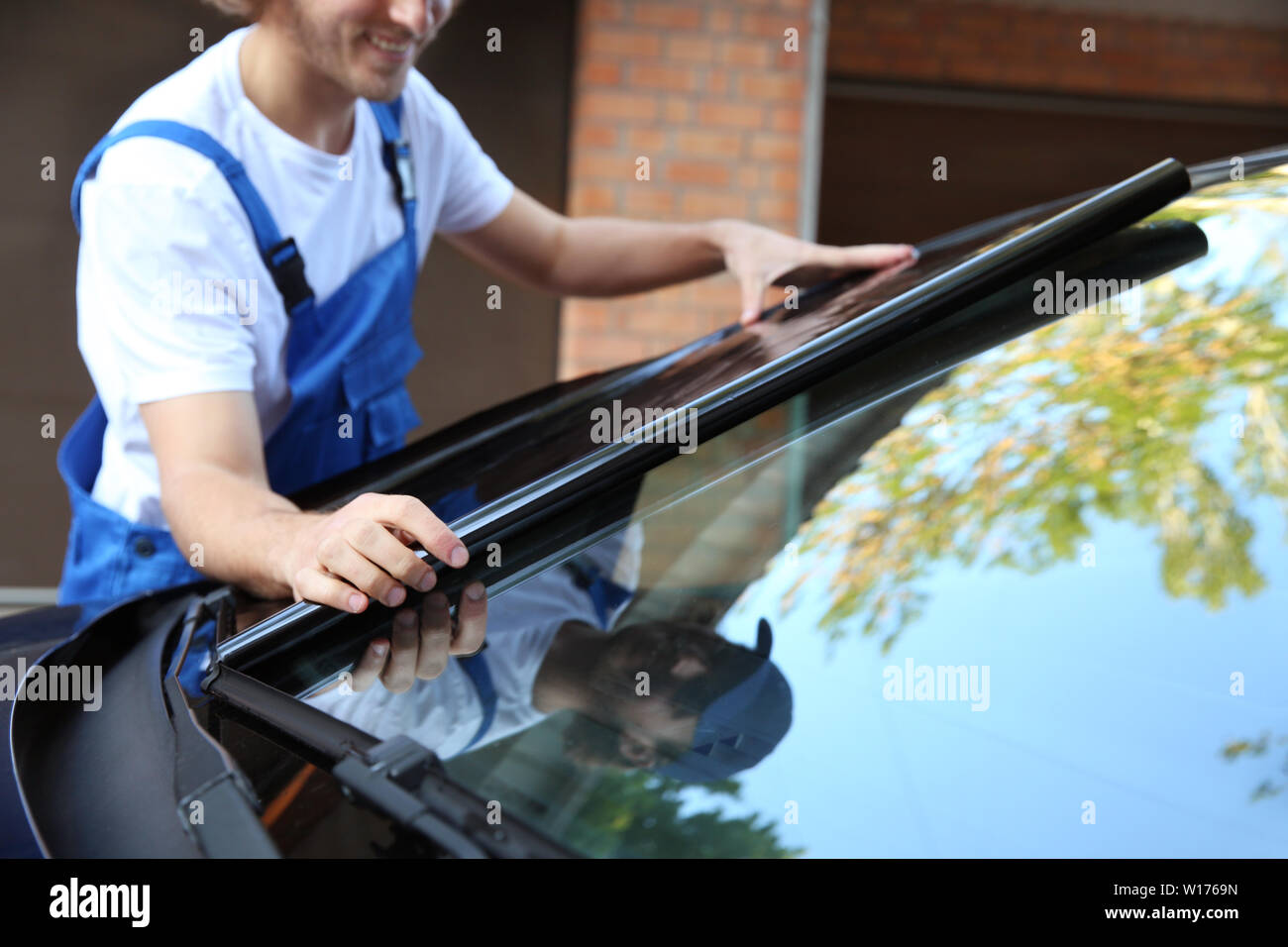 Male worker tinting car window outdoors Stock Photo - Alamy