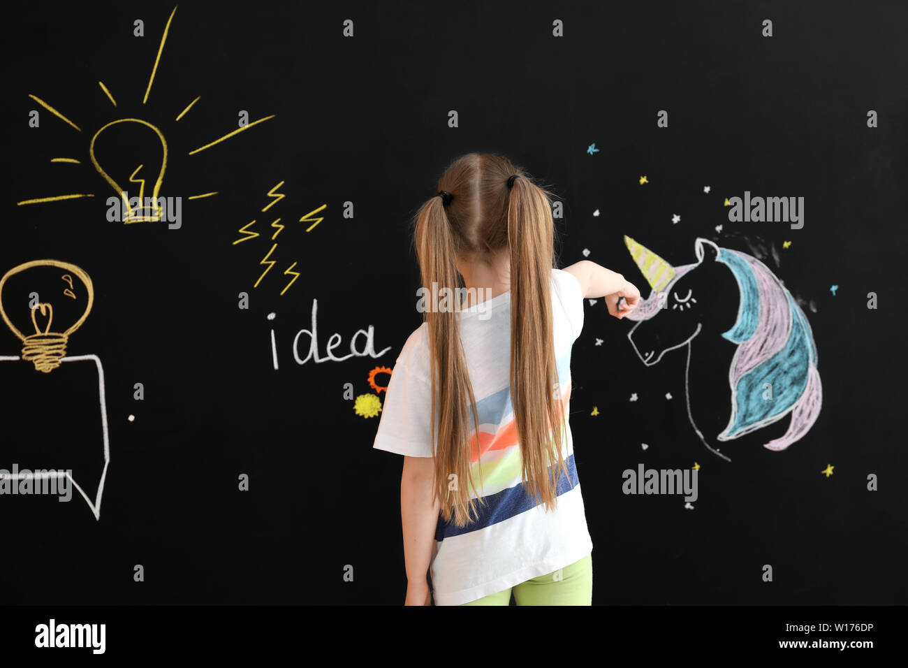 Cute little girl drawing on dark wall Stock Photo - Alamy