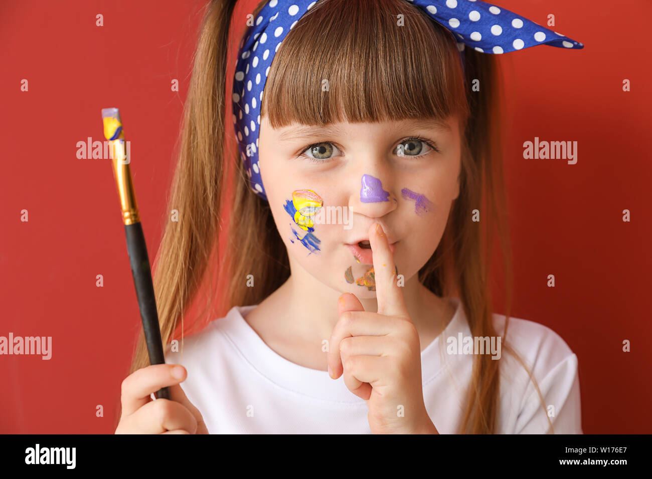 Cute little artist showing silence gesture on color background Stock ...