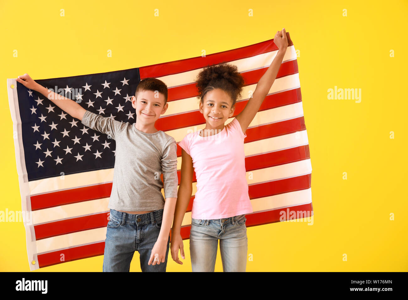 Cute children with national flag of USA on color background Stock Photo ...