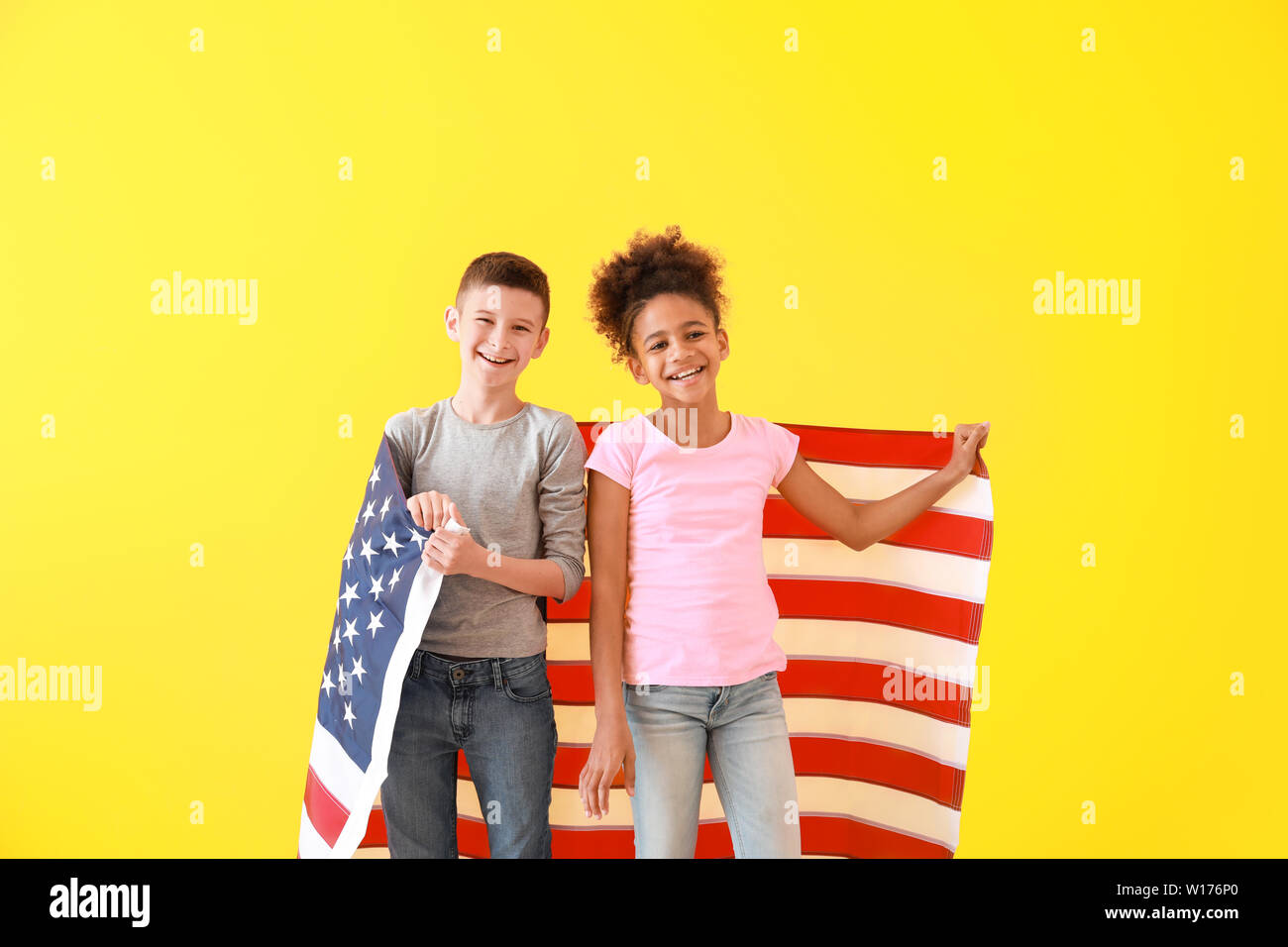 Cute children with national flag of USA on color background Stock Photo ...