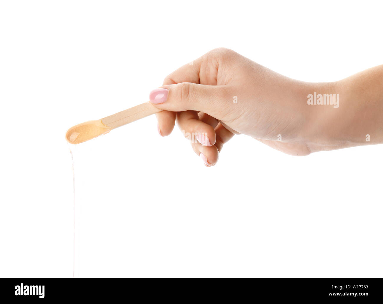 Female hand with sugaring paste on stick against white background Stock ...