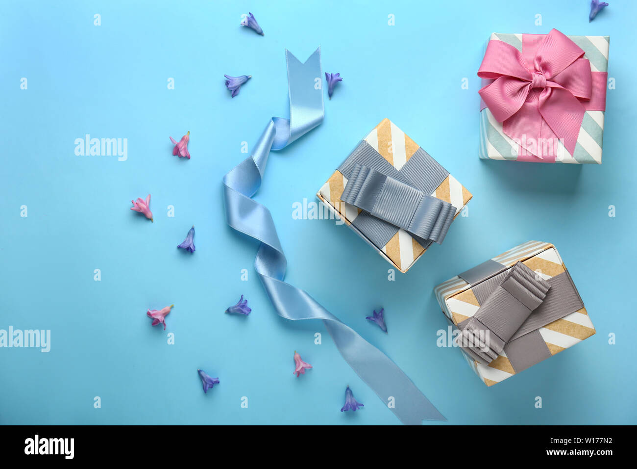 Beautiful gift boxes and flowers on color background Stock Photo - Alamy