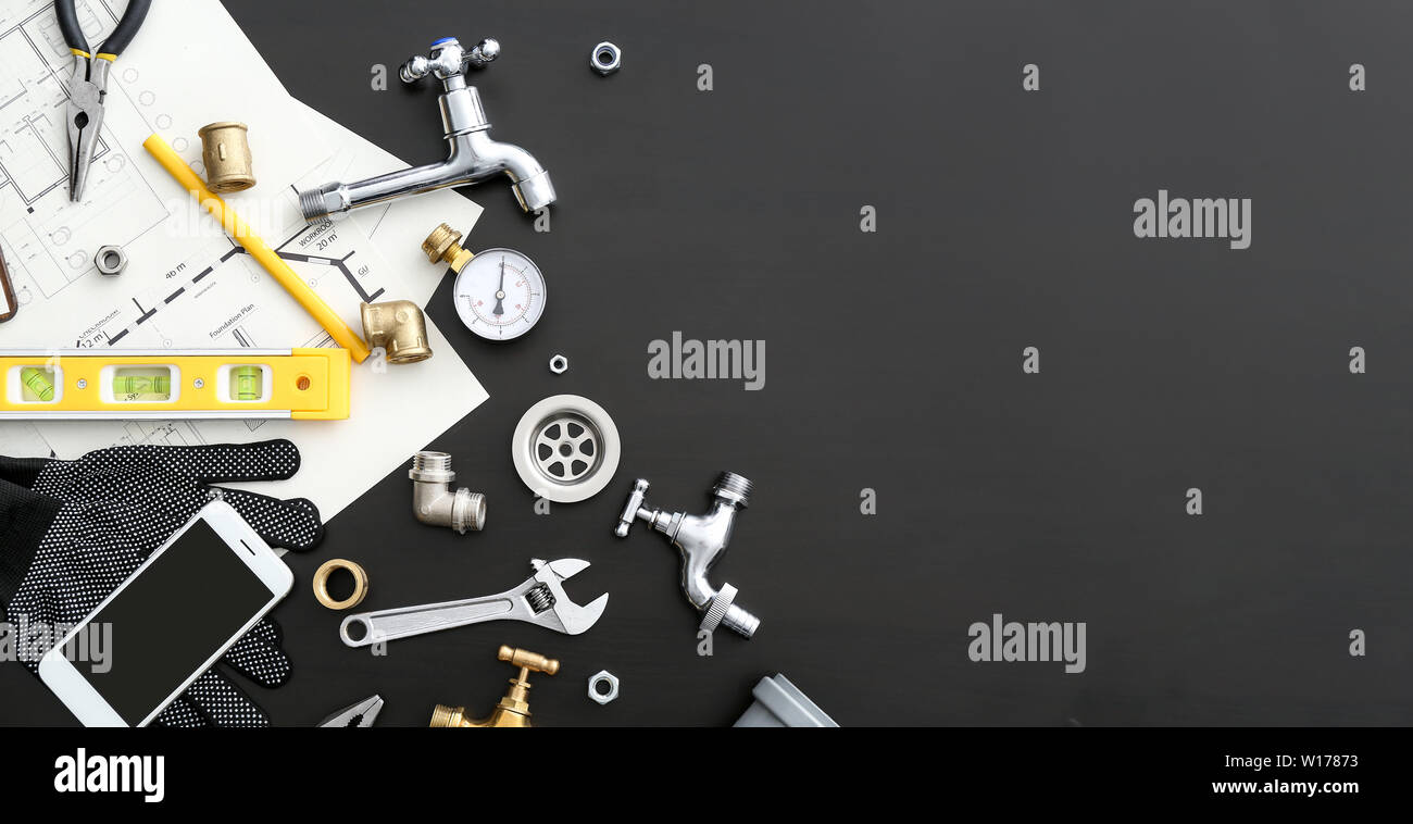 Mobile phone with plumbing items on dark background Stock Photo - Alamy