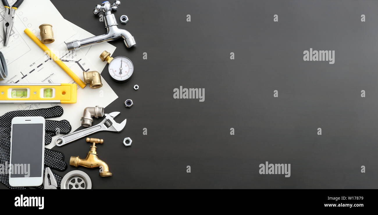 Mobile phone with plumbing items on dark background Stock Photo - Alamy