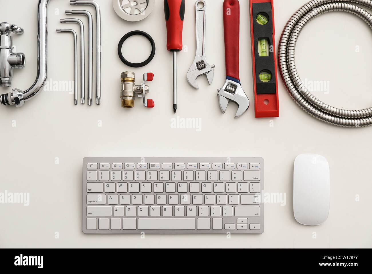 Computer keyboard and plumbing items on white background Stock Photo ...