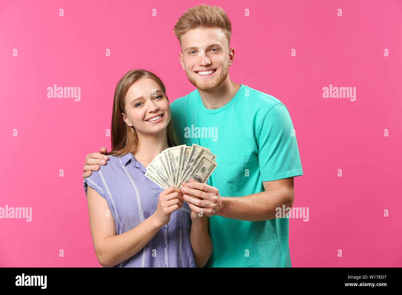 Happy couple with money on color background Stock Photo - Alamy