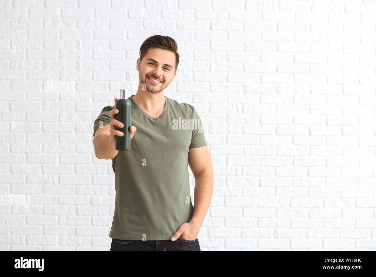 Handsome man with bottle of shampoo on white background Stock Photo - Alamy