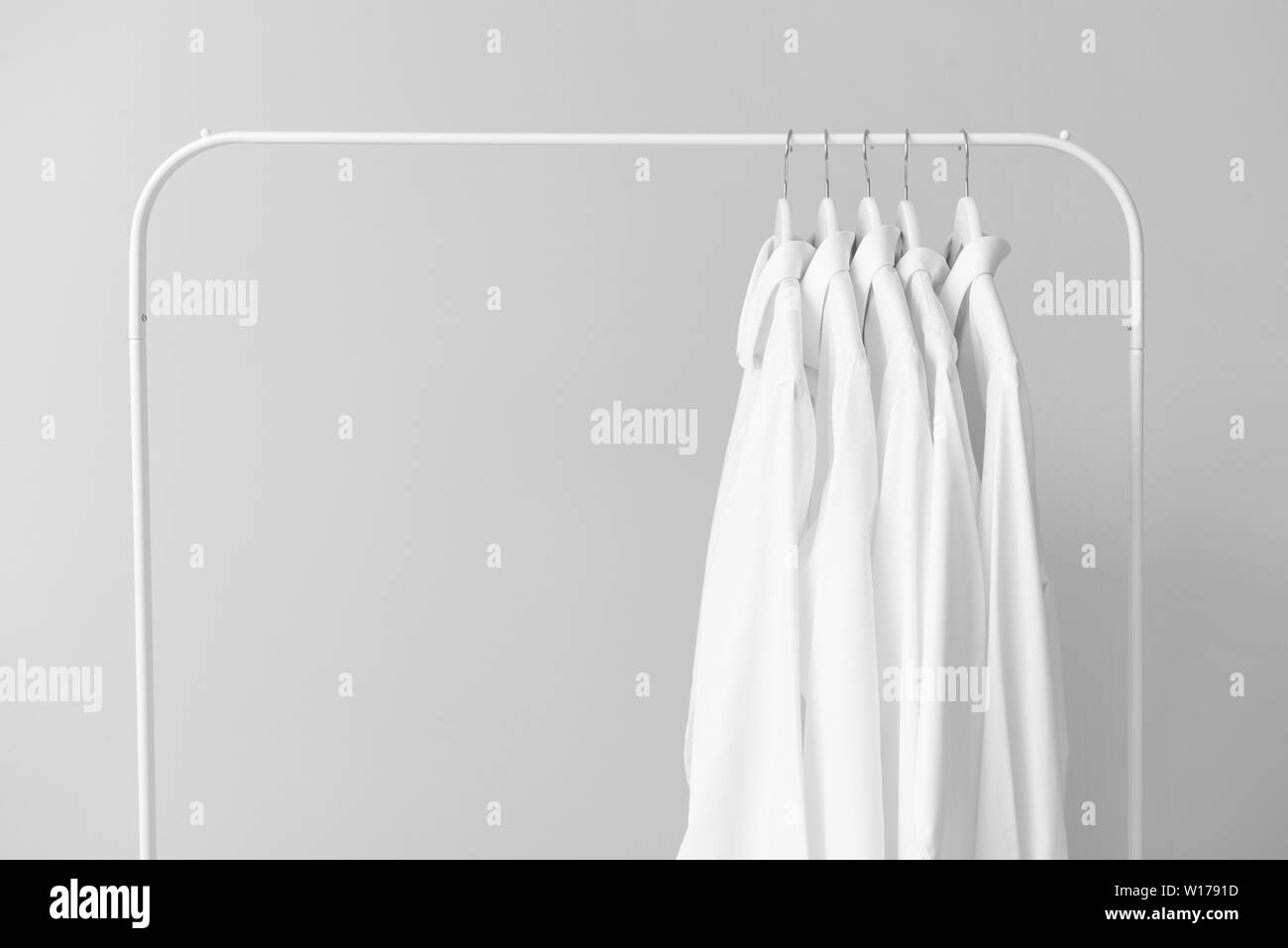 Rack with clothes after dry-cleaning on light background Stock Photo ...