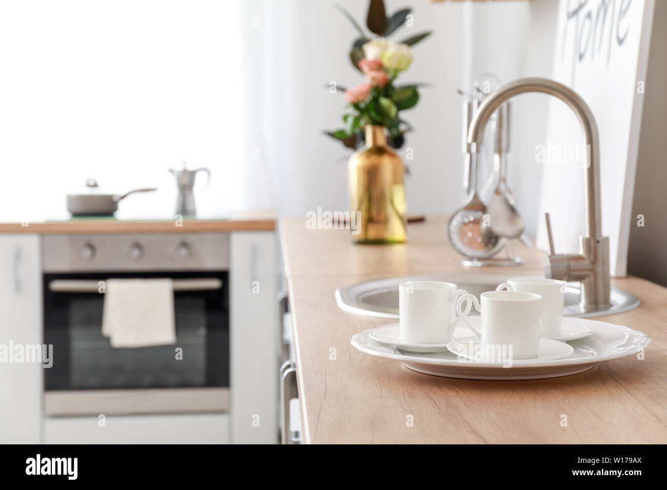 Plate and cups on kitchen counter Stock Photo - Alamy