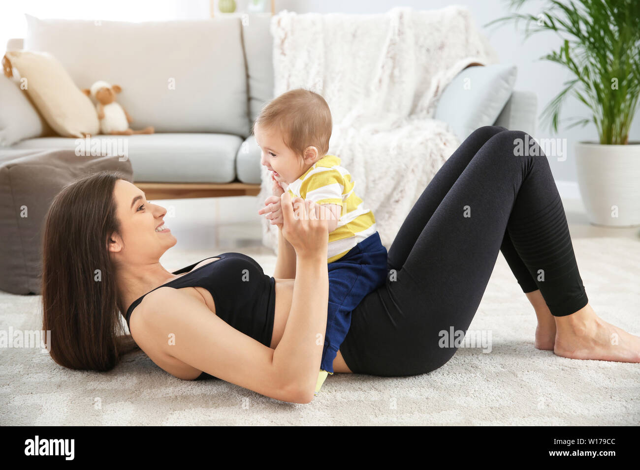 Mother training with cute little baby at home Stock Photo - Alamy