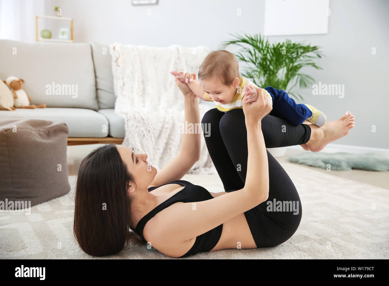 Mother training with cute little baby at home Stock Photo - Alamy