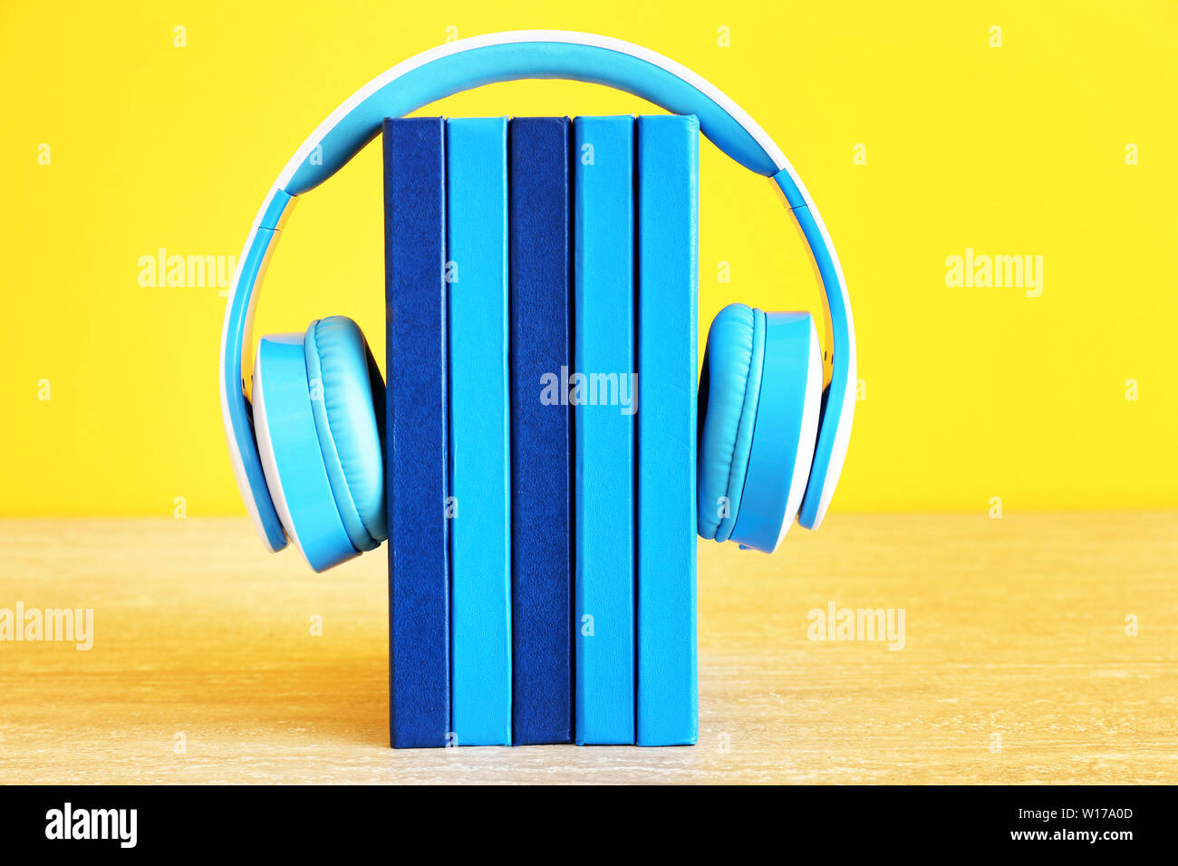 Books and modern headphones on table. Concept of audiobook Stock Photo ...