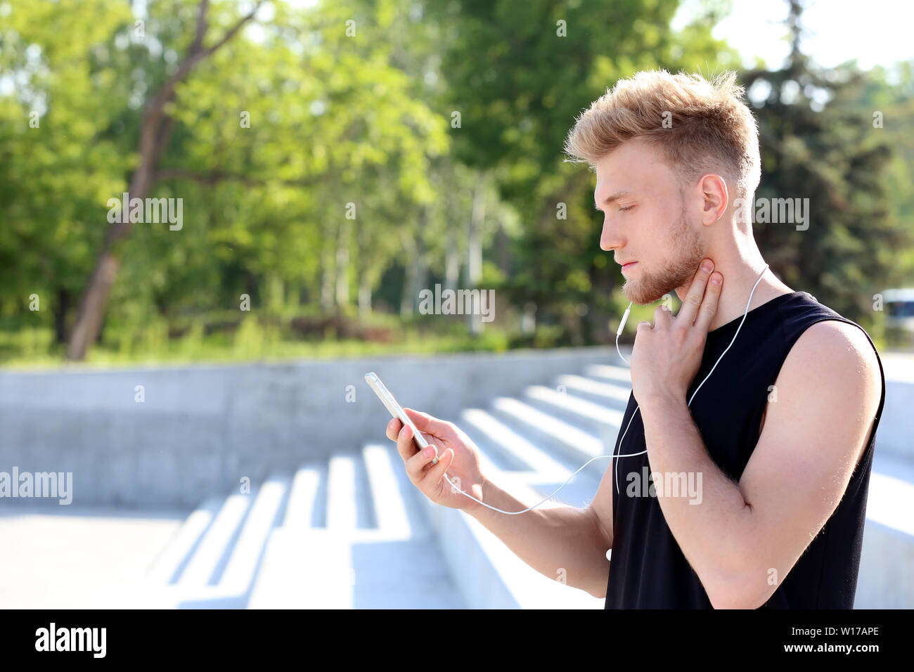 Sporty young man checking his pulse outdoors Stock Photo - Alamy
