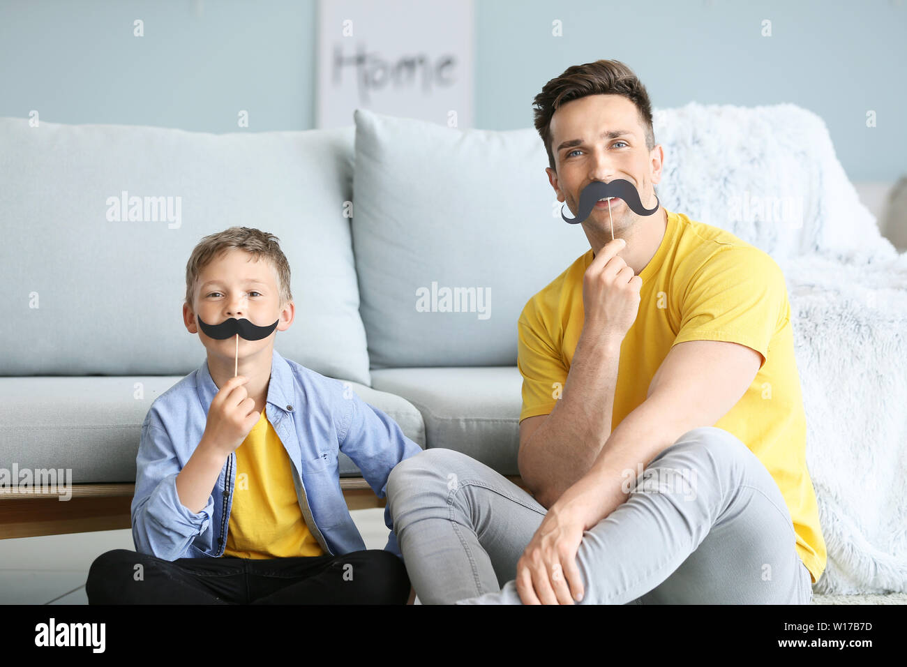 Portrait of funny father and son with fake mustache at home Stock Photo ...