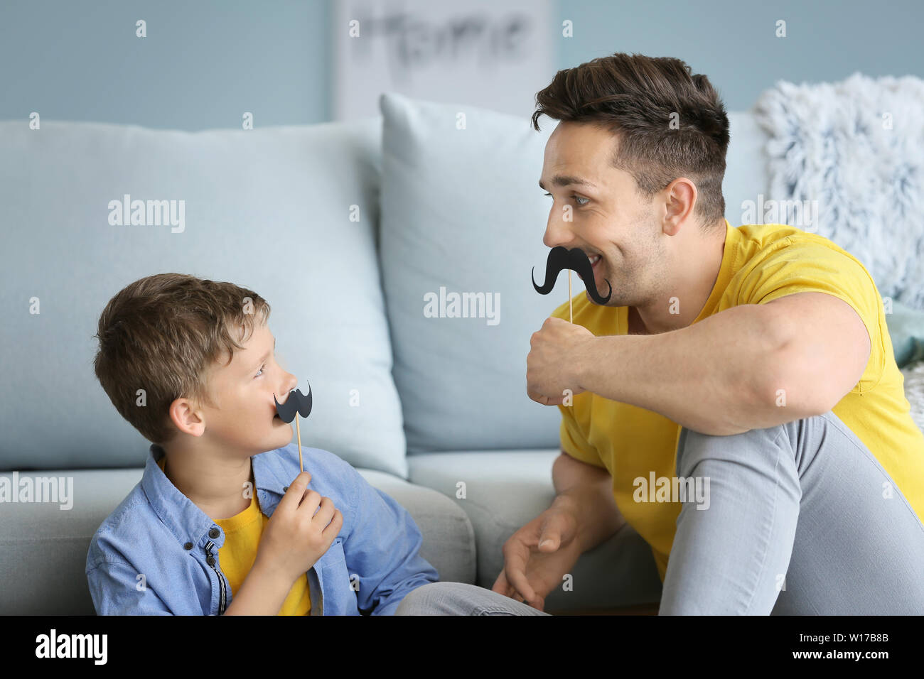 Portrait of funny father and son with fake mustache at home Stock Photo ...