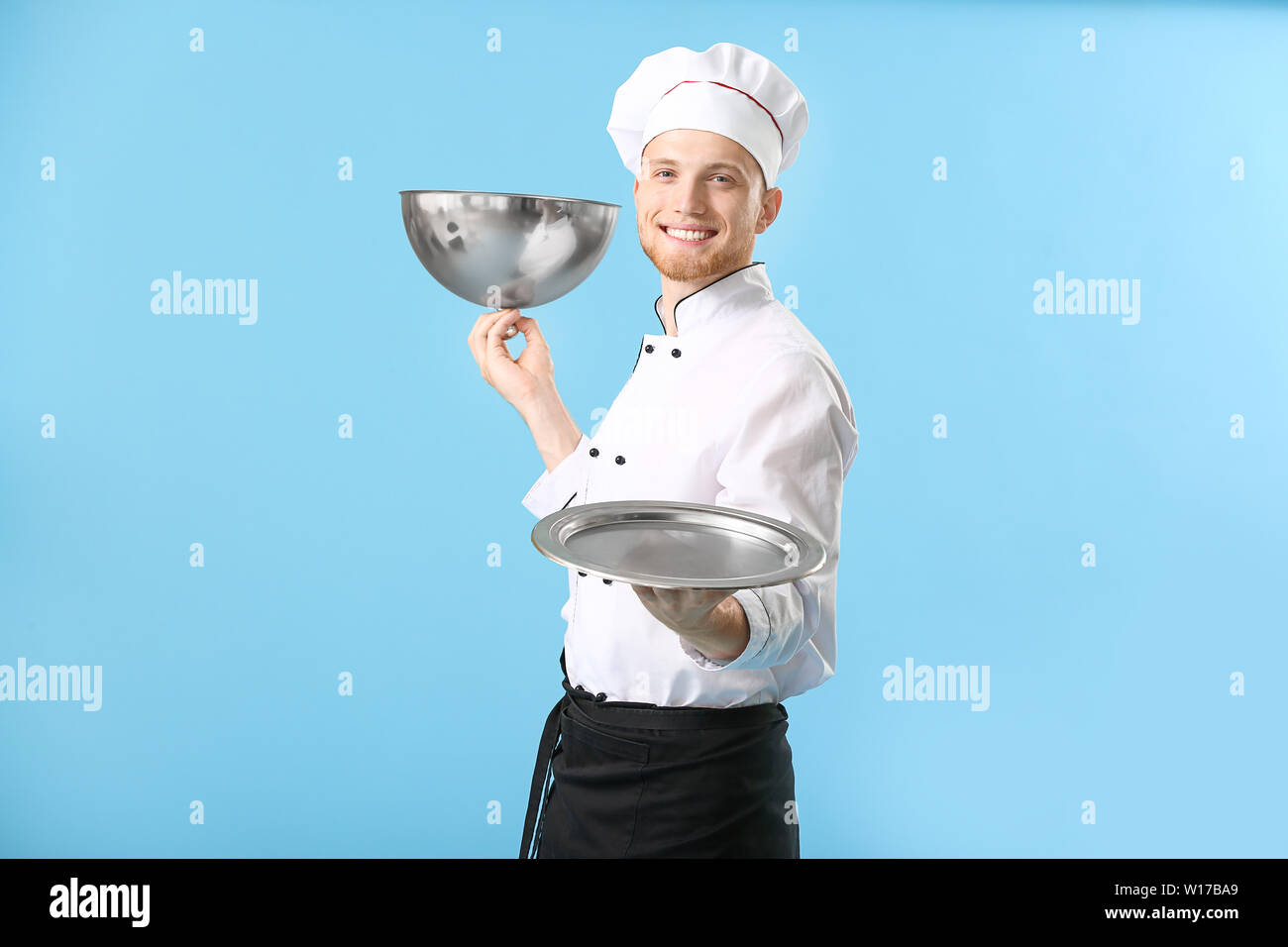 Handsome male chef with tray and cloche on color background Stock Photo ...