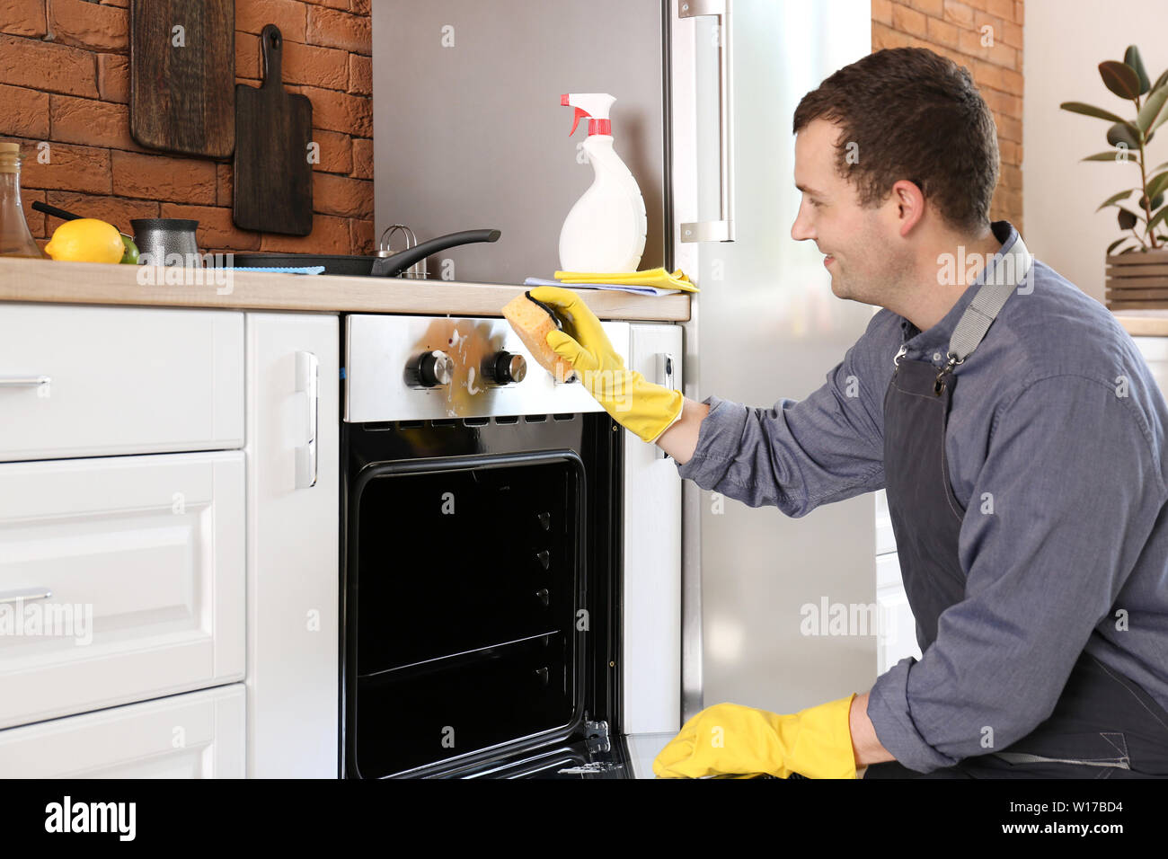 Man cleaning oven at home Stock Photo - Alamy