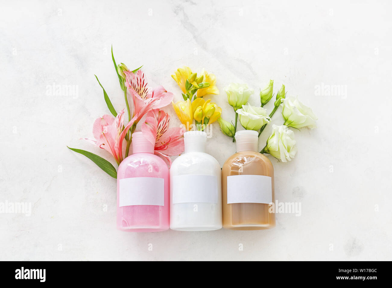 Bottles of shampoo and flowers on light background Stock Photo - Alamy