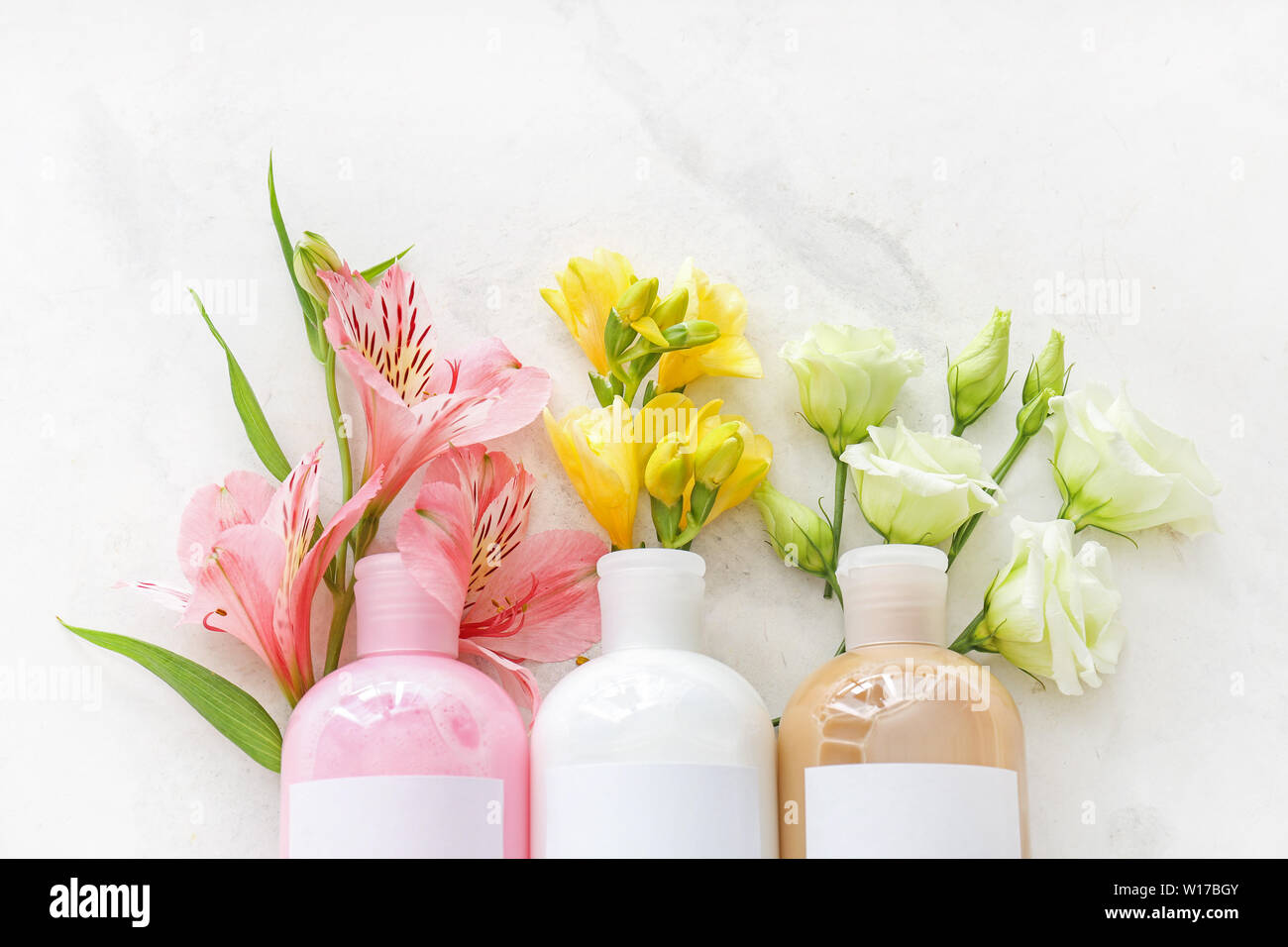 Bottles of shampoo and flowers on light background Stock Photo - Alamy