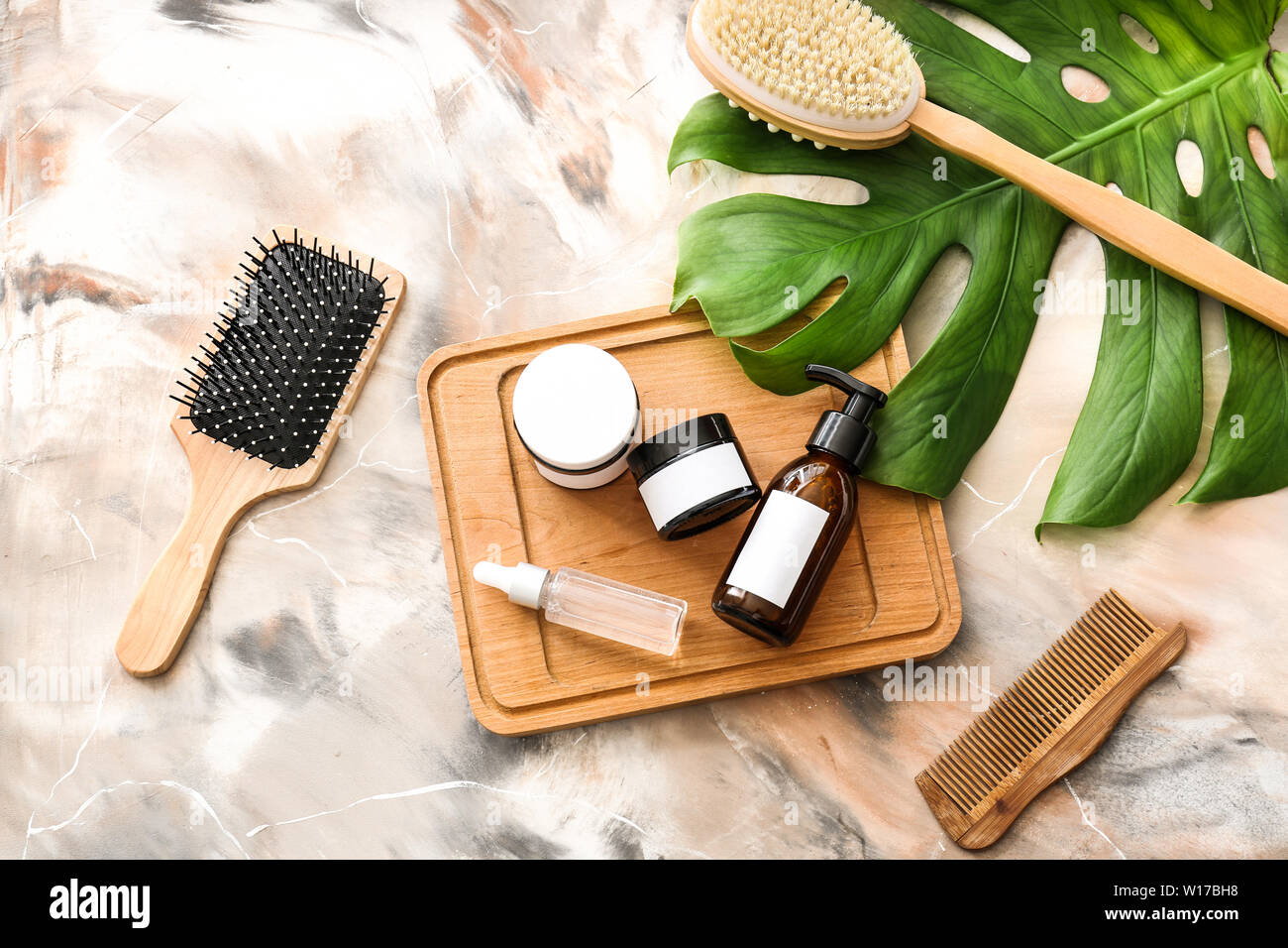Shampoo, brushes and tropical leaf on marble background Stock Photo - Alamy