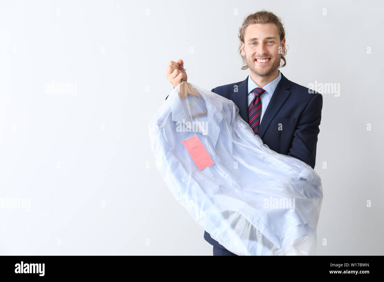 Businessman with clothes after dry-cleaning on white background Stock ...