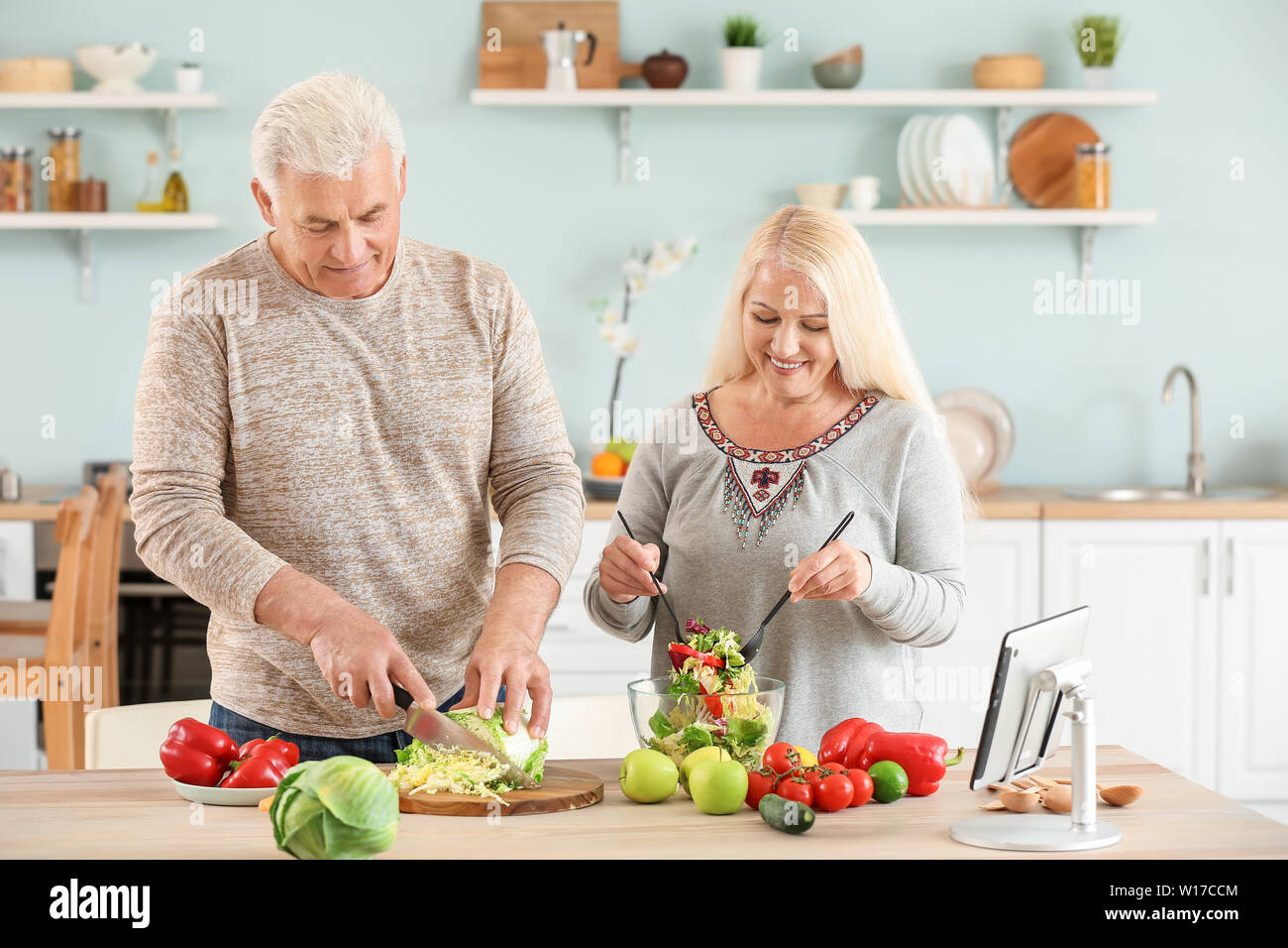 Portrait of happy mature couple cooking in kitchen Stock Photo - Alamy