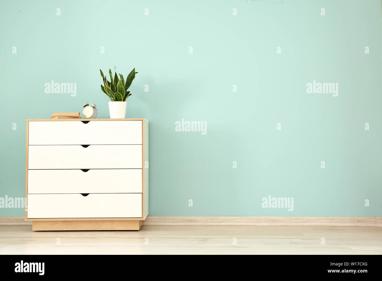 Chest of drawers near color wall Stock Photo - Alamy