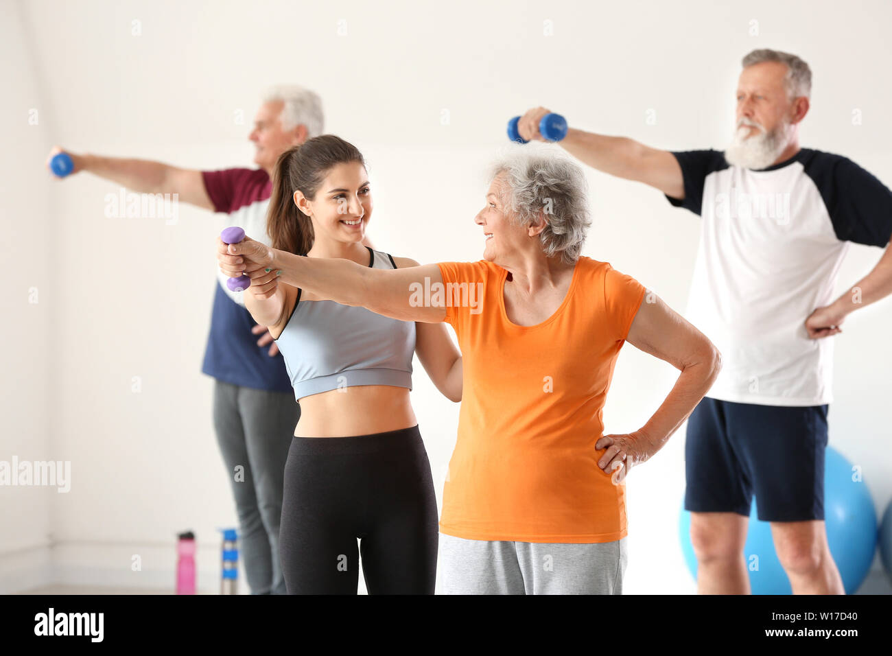 Elderly people training with instructor in gym Stock Photo - Alamy