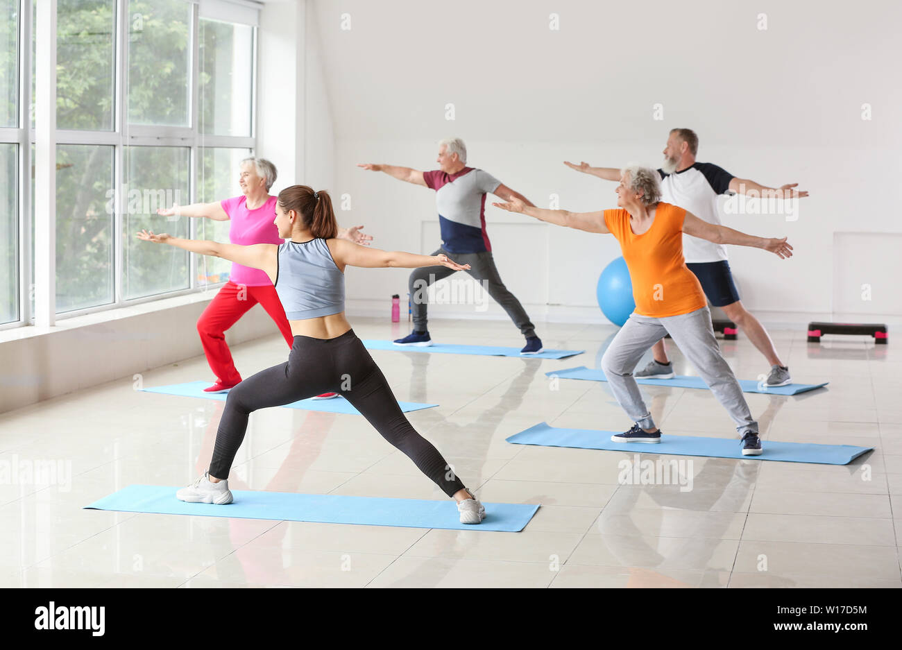 Elderly people training with instructor in gym Stock Photo - Alamy