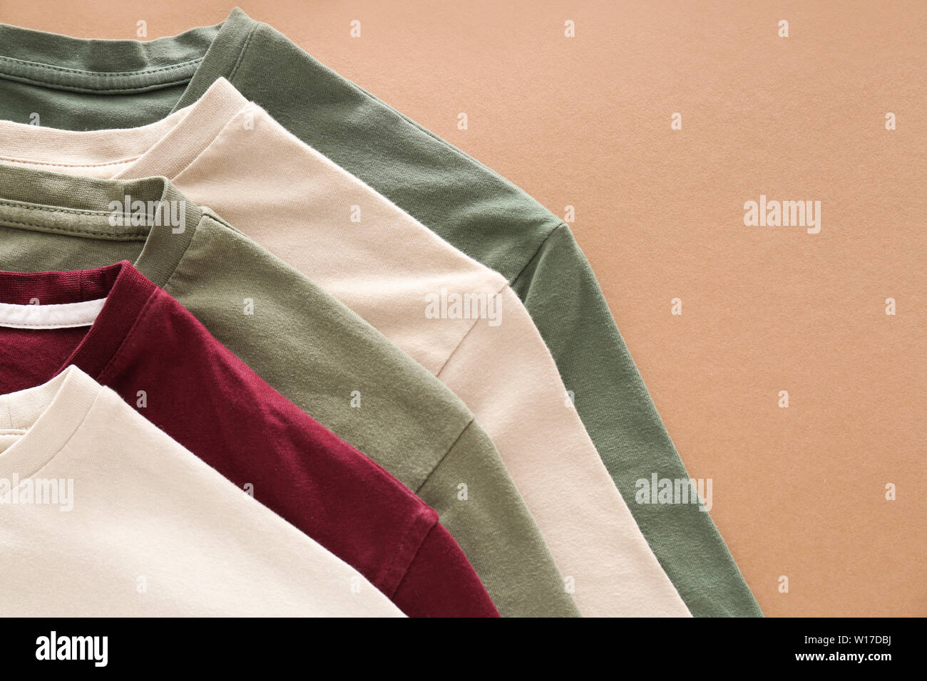 Different t-shirts on color background Stock Photo - Alamy