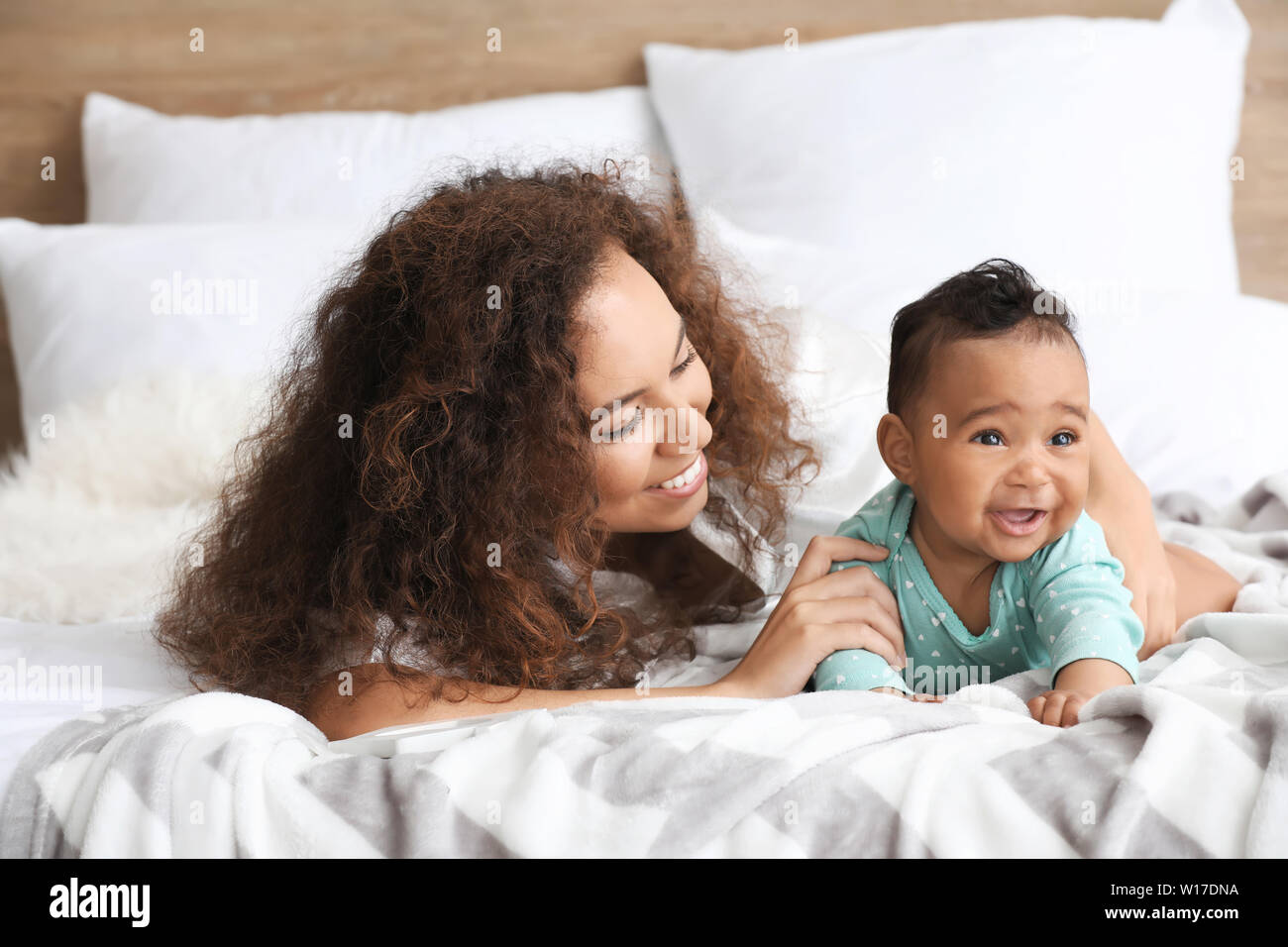 Happy African-American mother with cute little baby in bedroom Stock Photo - Alamy