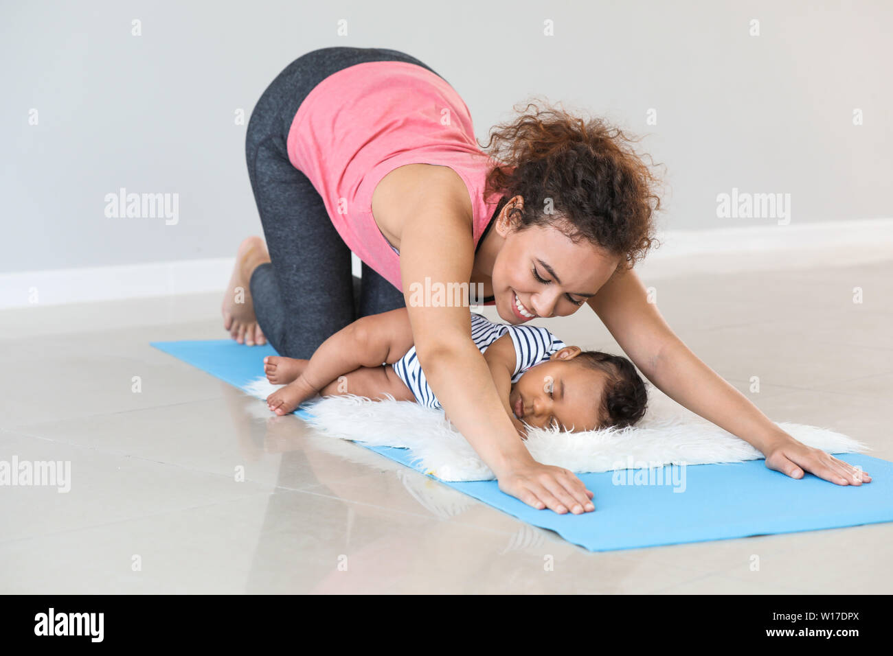 African-American mother training with cute little baby at home Stock ...
