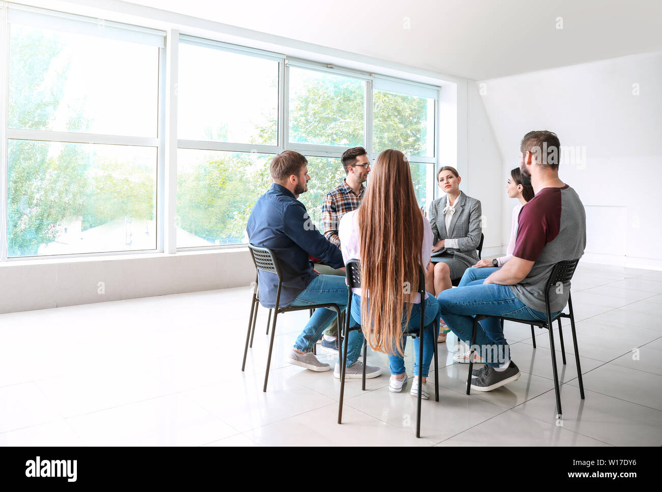 Young people with psychologist at group therapy session Stock Photo - Alamy